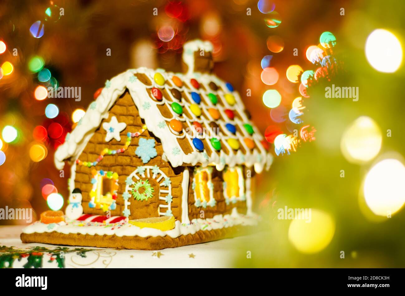 gingerbread house with blurred garland lights background Stock Photo ...