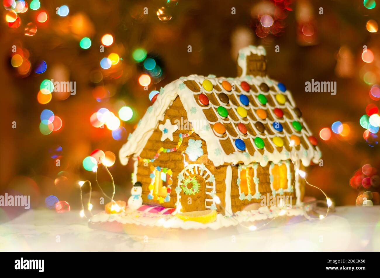gingerbread house with blurred garland lights background Stock Photo ...