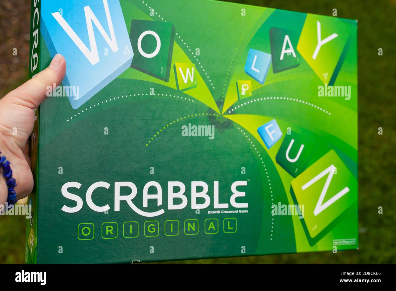 High-Resolution close-up of hand holding Scrabble Original Board Game ...