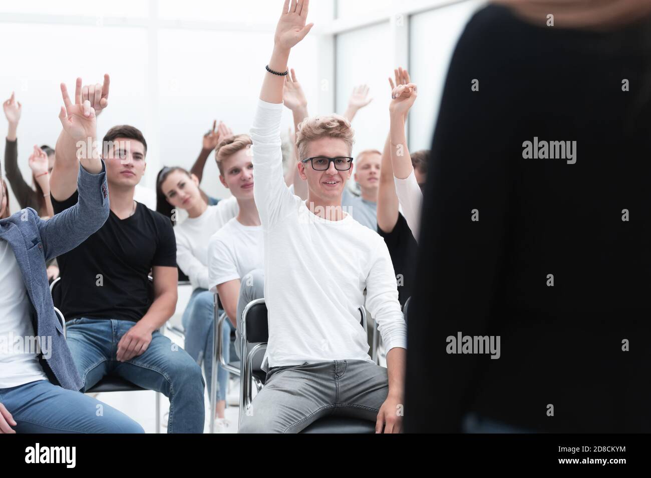 group of young people raising their hands to ask a question Stock Photo ...