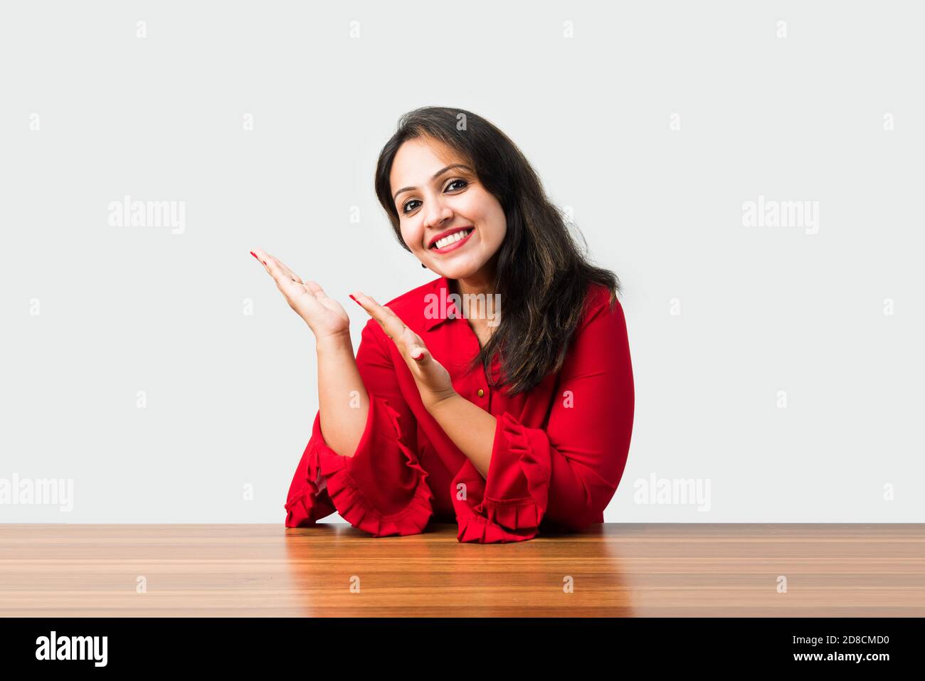 Indian asian pretty woman standing at table resting chin on hands Stock ...