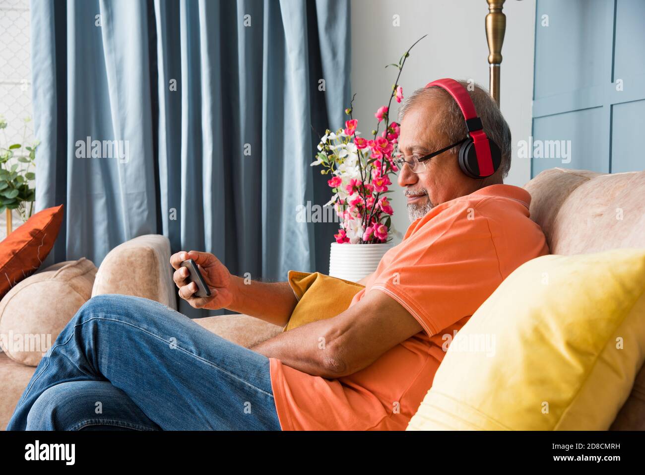 Indian asian old man using headphones while listning to music or ...