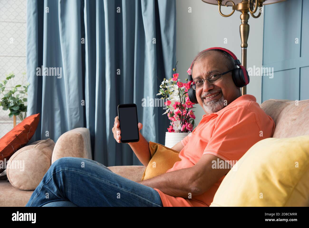 Indian asian old man using headphones while listning to music or ...
