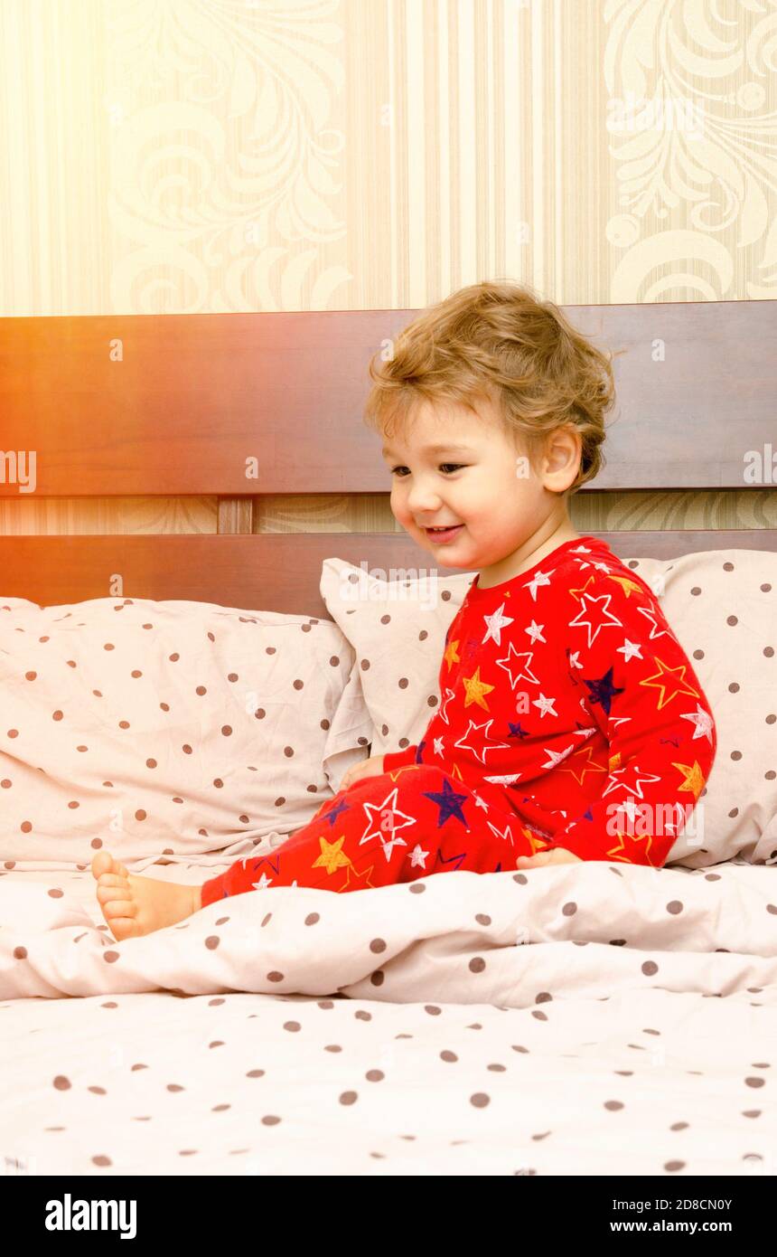 little boy in pajamas on the bed Stock Photo - Alamy