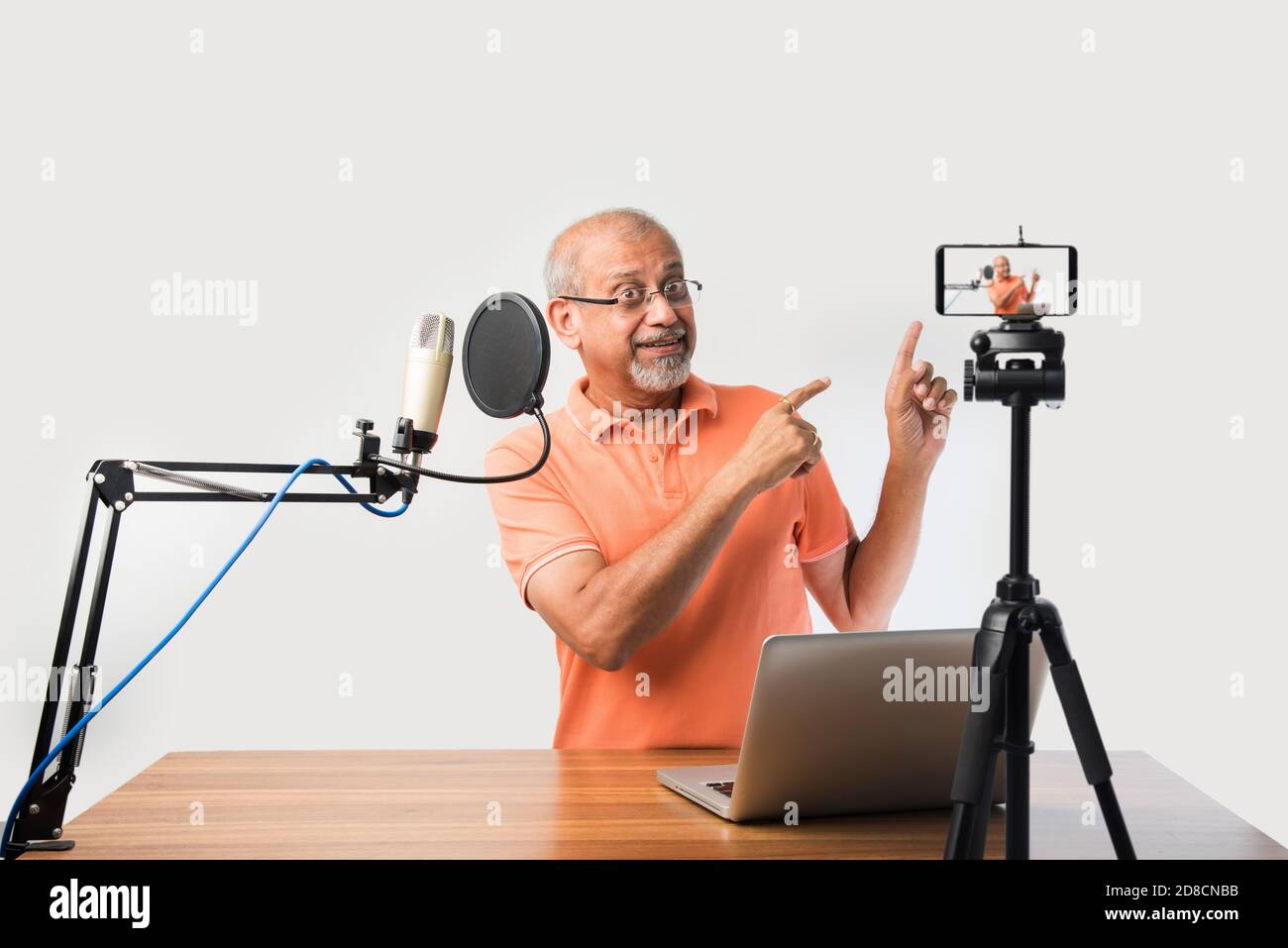 Confident Indian old man speaking in recording mic with filter while ...