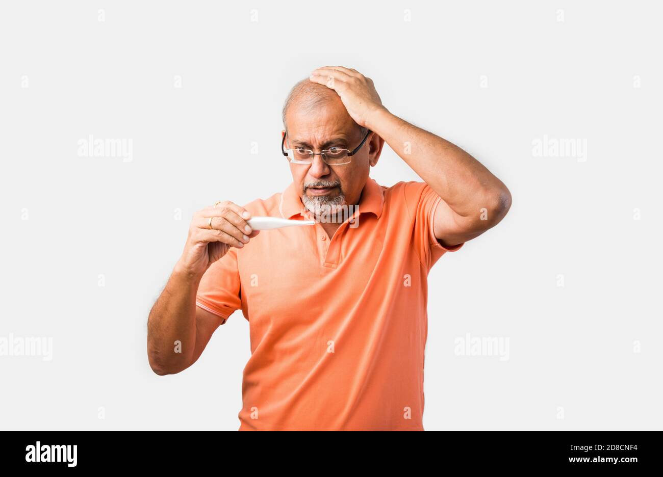 Indian asian senior or old man checking temperature using thermometer ...