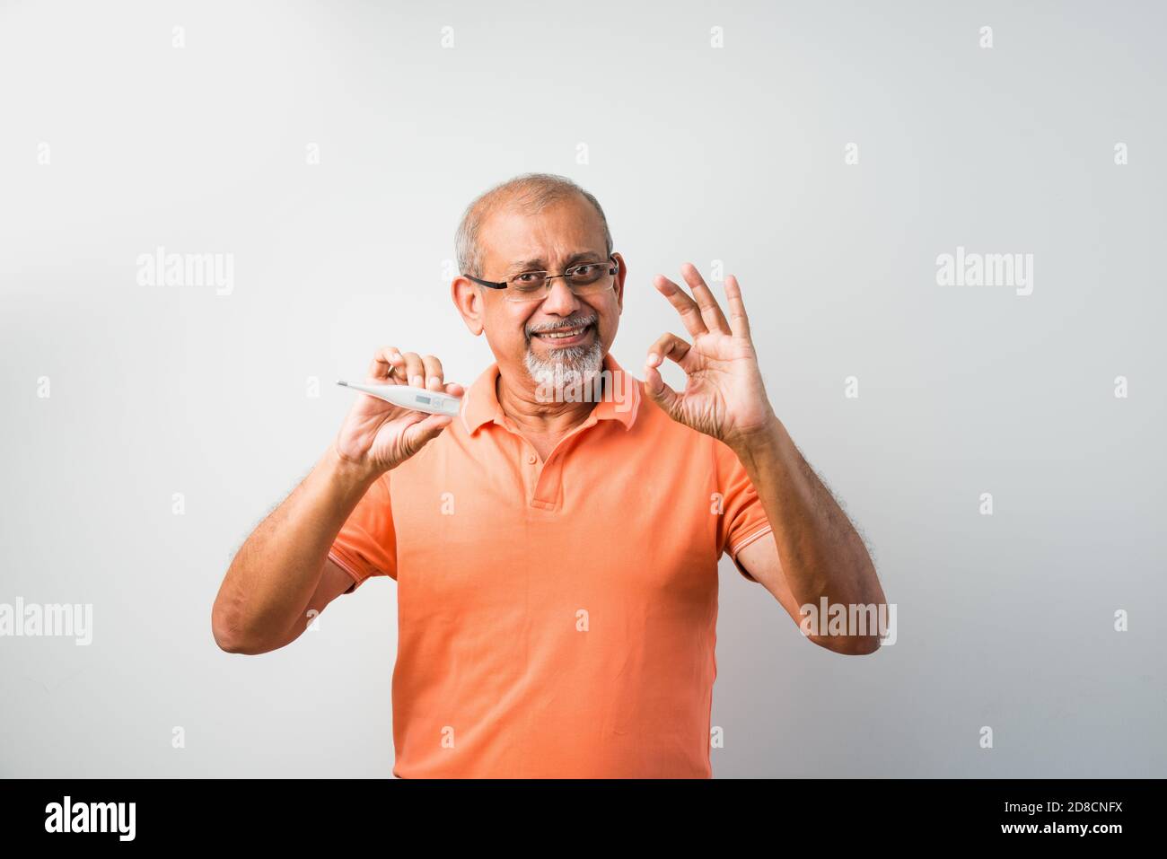 Indian asian senior or old man checking temperature using thermometer ...
