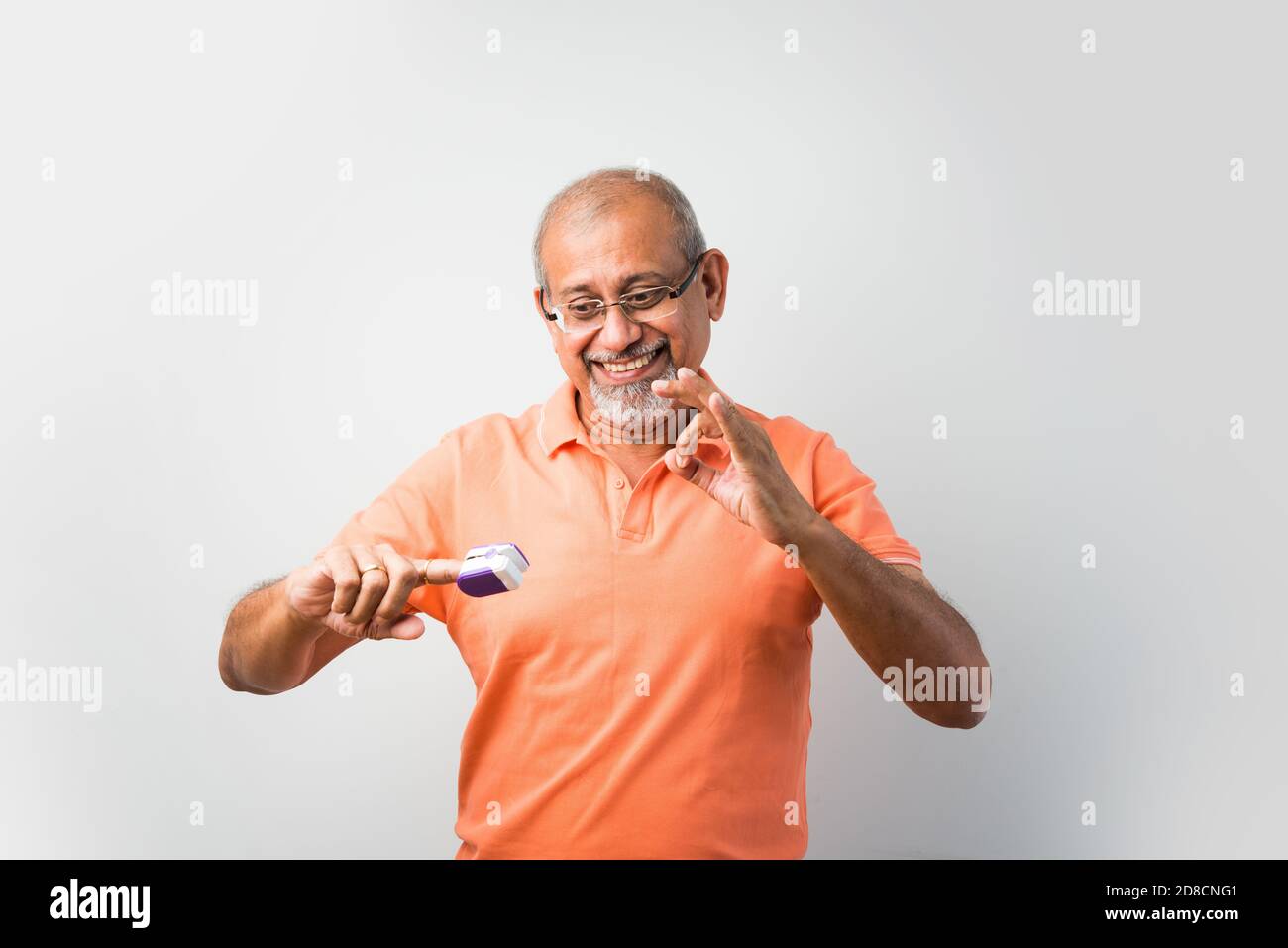 Indian asian senior or old man checking temperature using thermometer ...