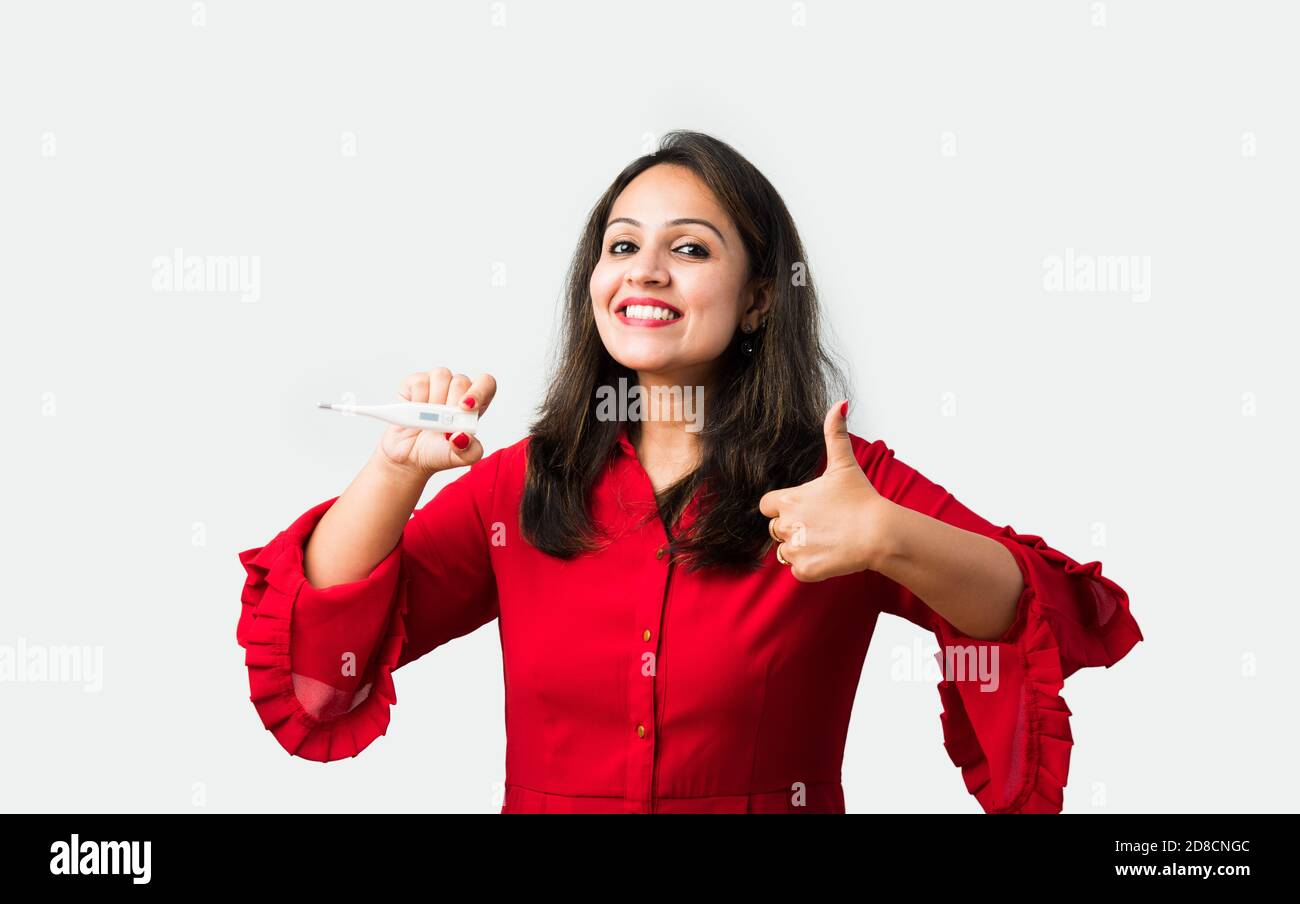 Indian asian young woman checking temperature with thermometer or ...