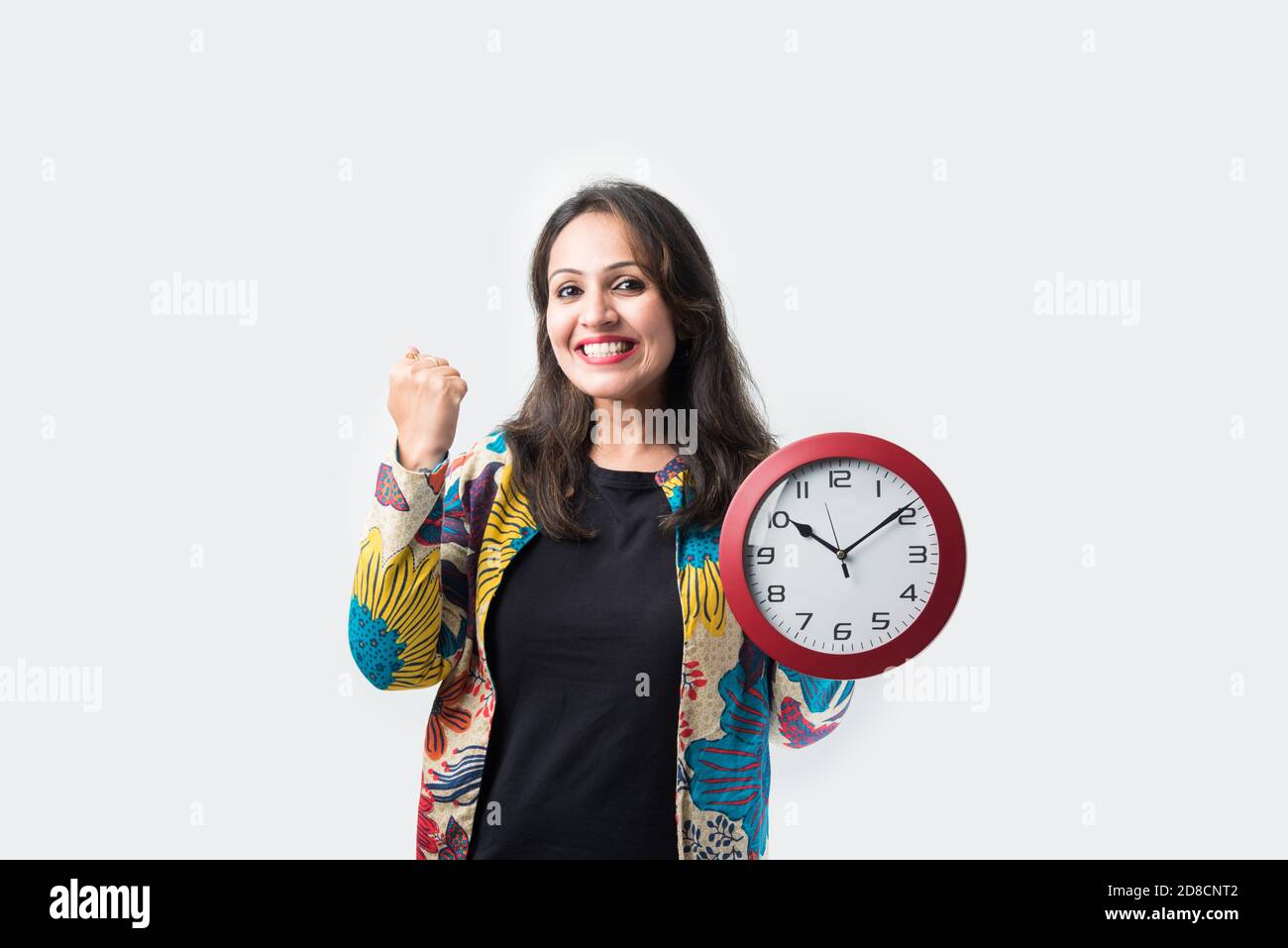 Pretty Asian Indian woman or young lady holding round wall clock - time ...