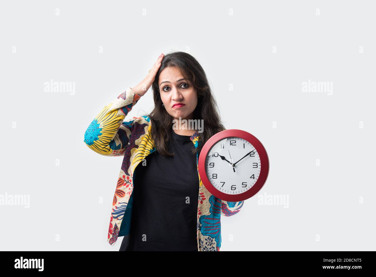 Pretty Asian Indian woman or young lady holding round wall clock - time ...