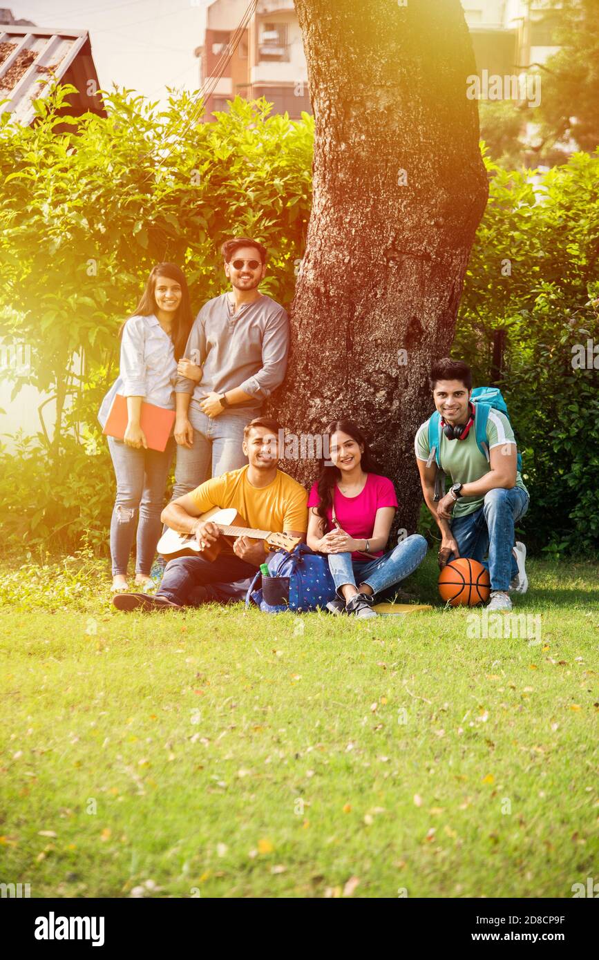 Asian Indian college students playing music with guitar while sitting ...