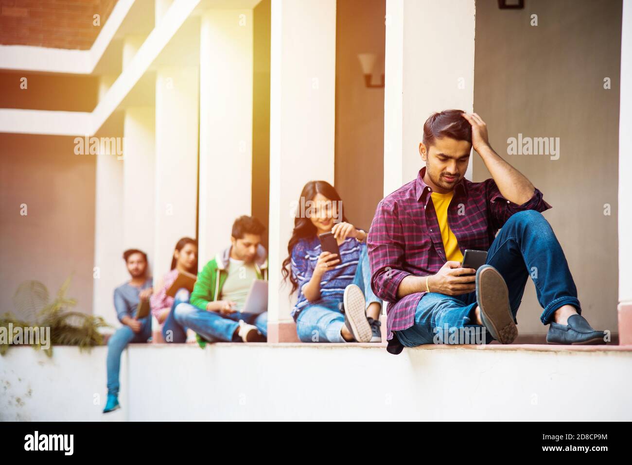 Asian Indian college students using smartphone while sitting in college ...