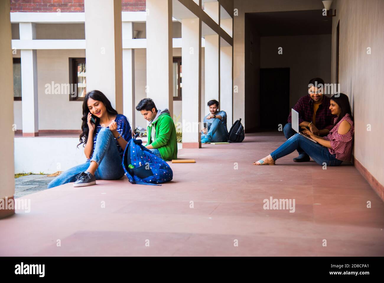 Asian Indian college students using smartphone while sitting in college ...