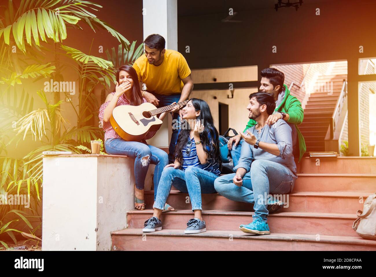 Asian Indian college students playing music with guitar while sitting ...