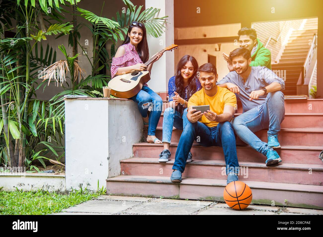 Asian Indian college students playing music with guitar while sitting ...