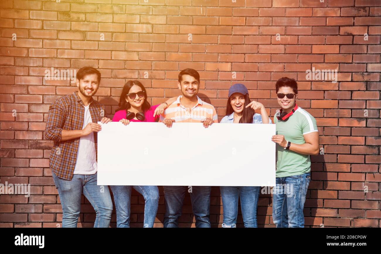 Asian Indian college students Holding or showing empty white board or ...