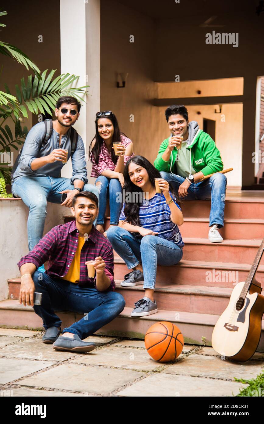 Asian Indian group of college students having tea of coffee together in ...