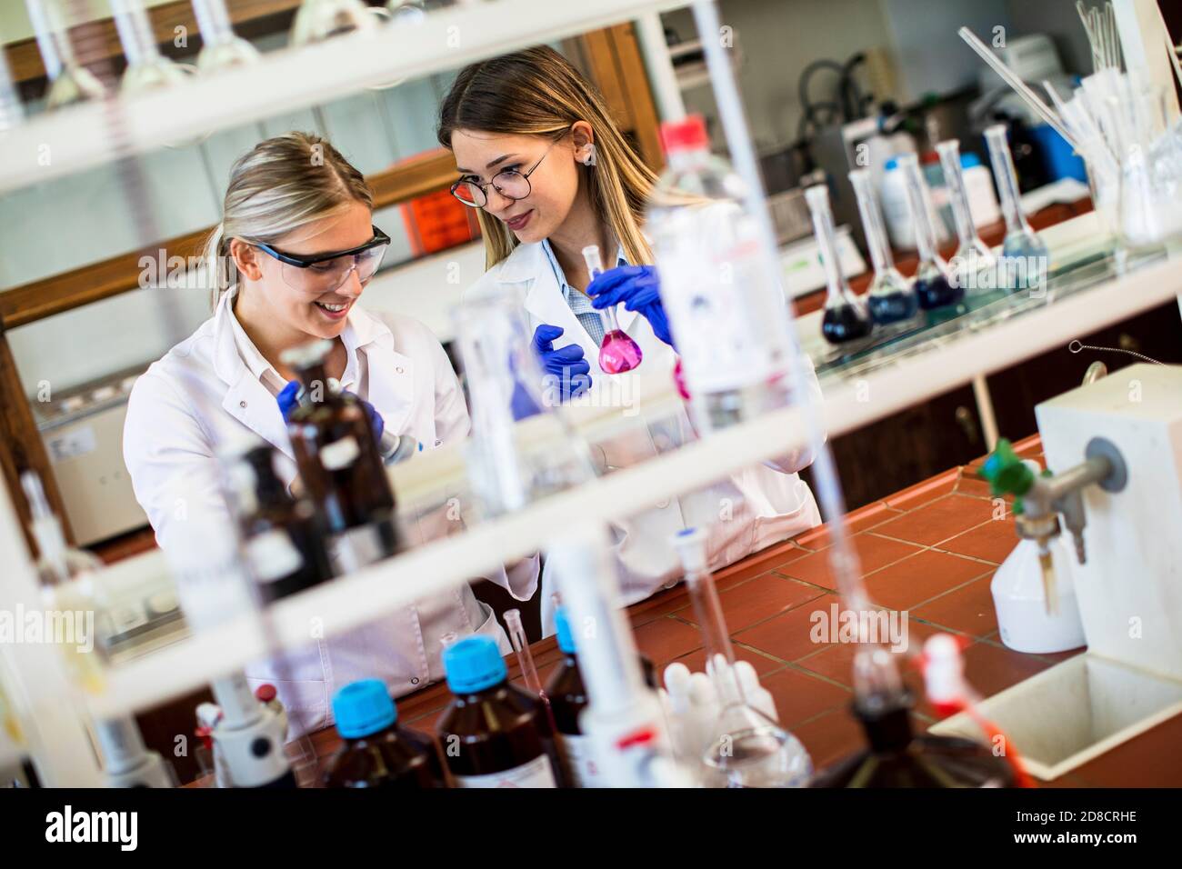 Cute female researchers in white lab coat working in the laboratory ...