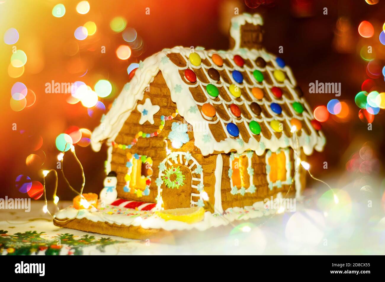 gingerbread house with blurred garland lights background Stock Photo ...