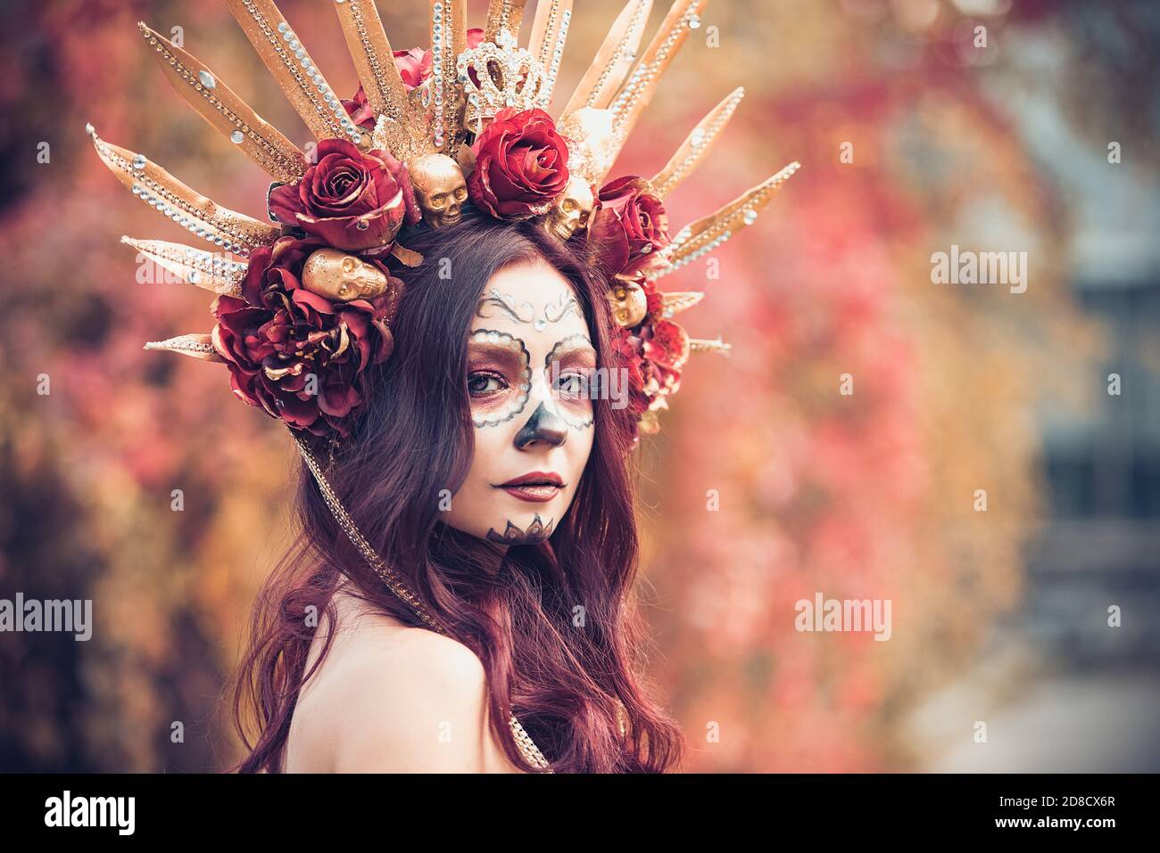 Closeup portrait of Calavera Catrina in red dress. Sugar skull makeup ...