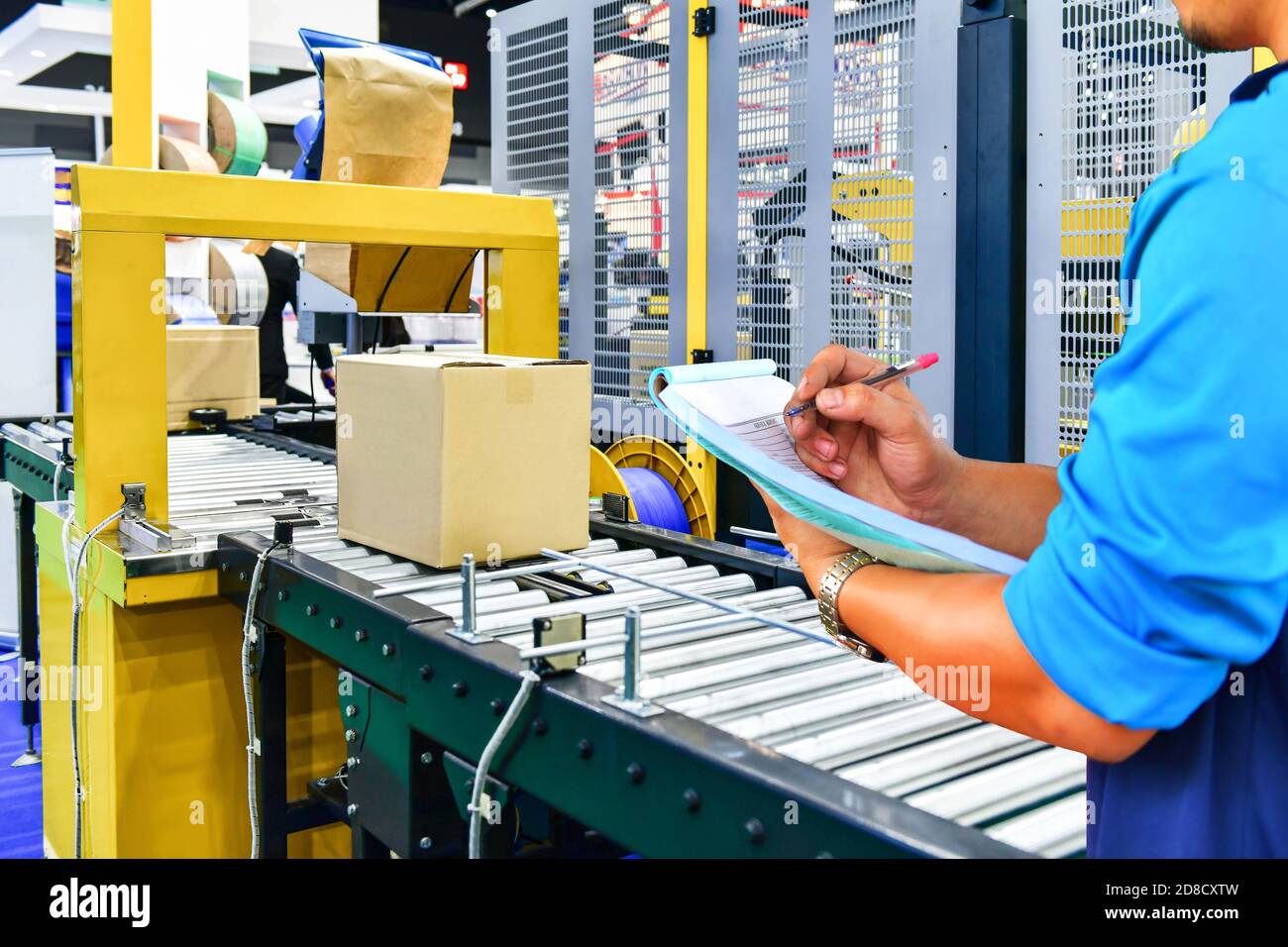 Manager engineer checking cardboard boxes on conveyor belt in ...