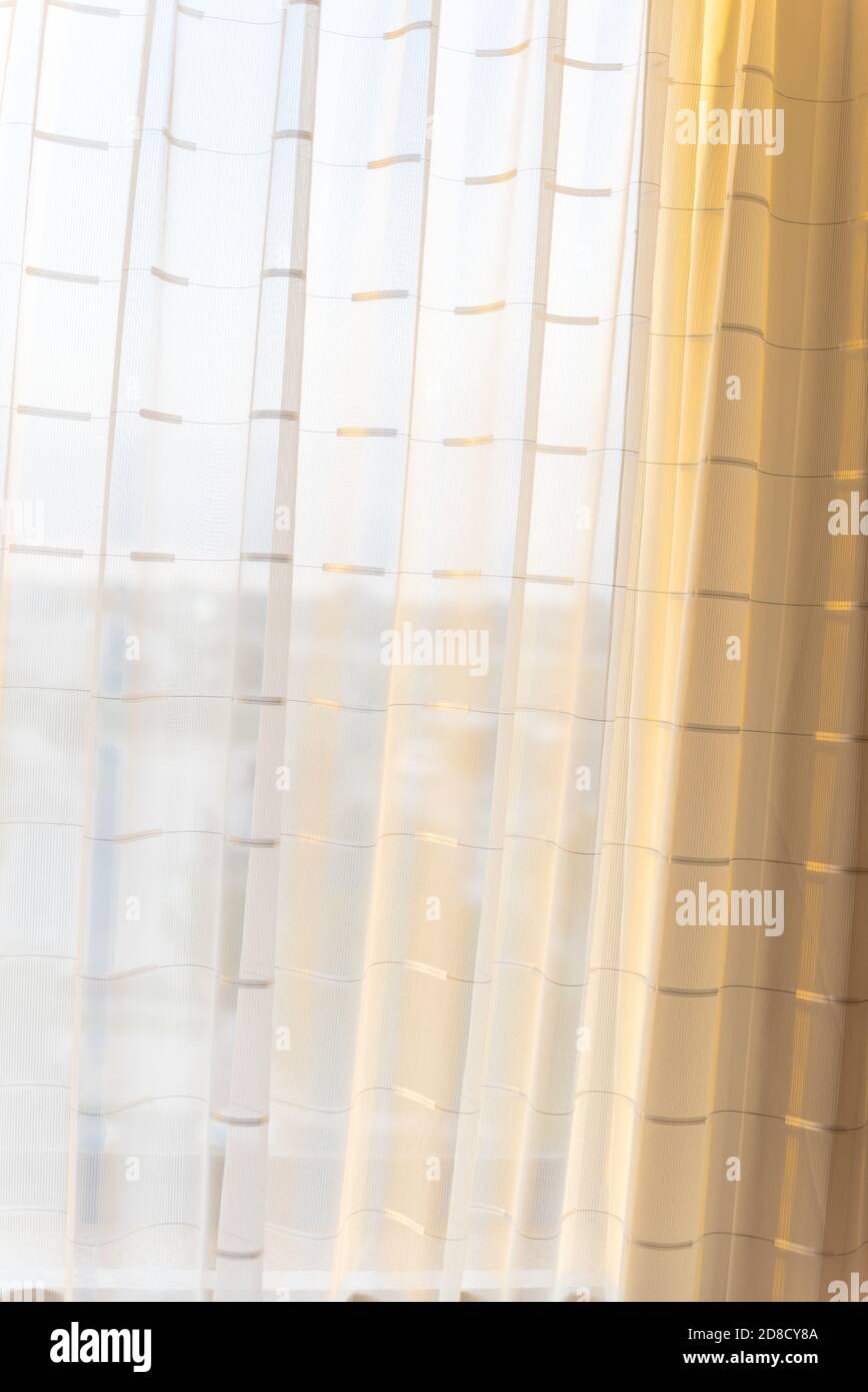 White curtain with backlit morning light at window facing room in ...