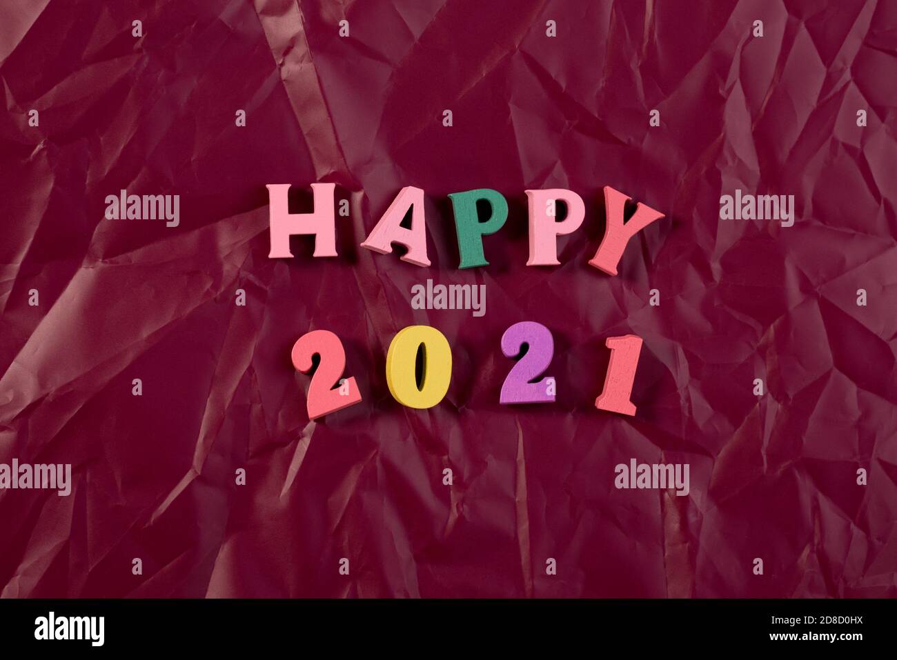 Happy New Year greeting words made of wooden letters, on a purple ...