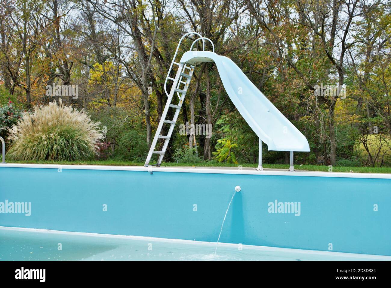 backyard swimming pool with pool slide emptied out shutting down for ...