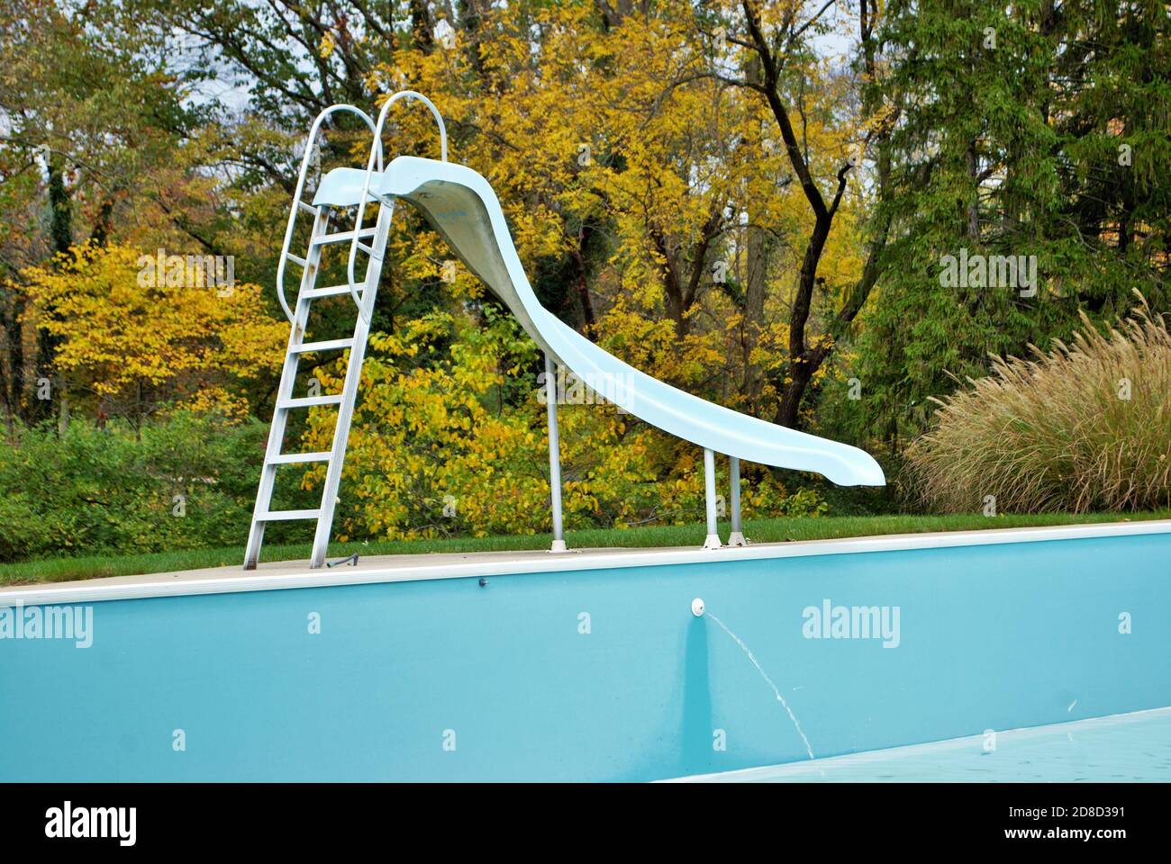 backyard swimming pool with pool slide emptied out shutting down for ...