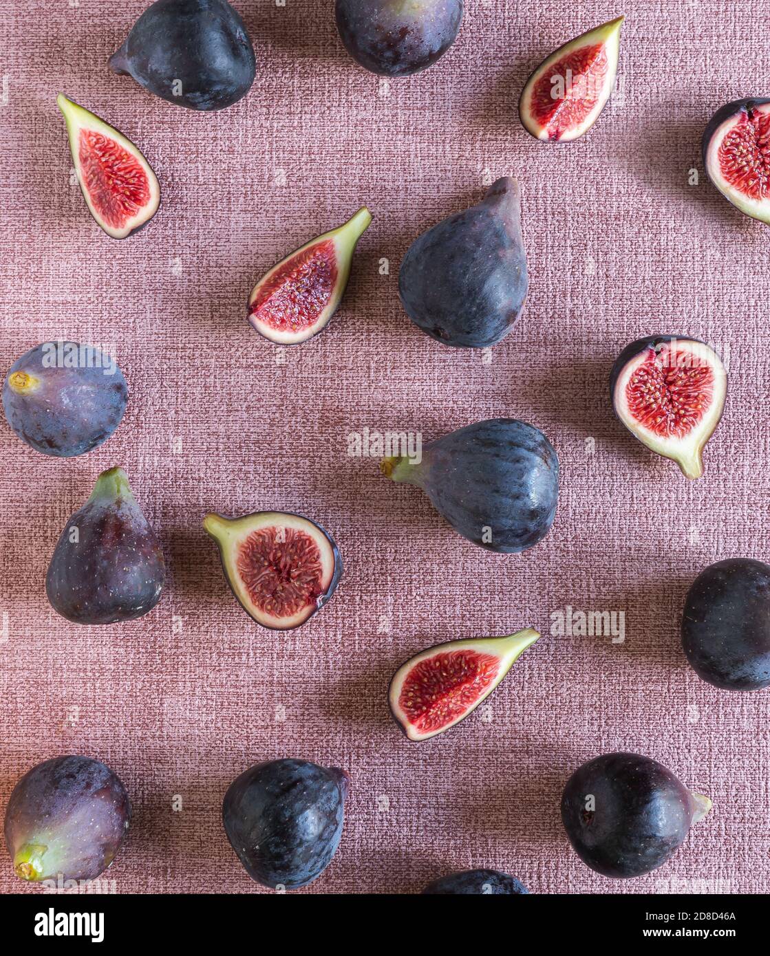 fresh cut and whole figs lying on pink textured background Stock Photo ...