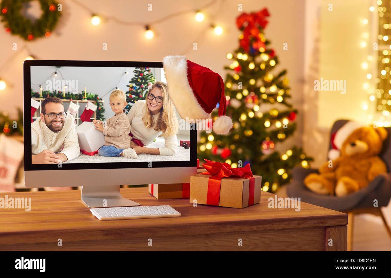 Desktop computer with happy young family opening their Christmas ...