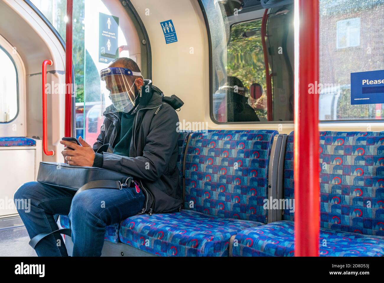 LONDON, ENGLAND - OCTOBER 23, 2020: Indian man wearing a face shield ...