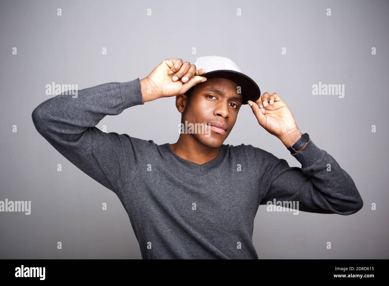 Portrait of cool african american guy holding cap Stock Photo - Alamy