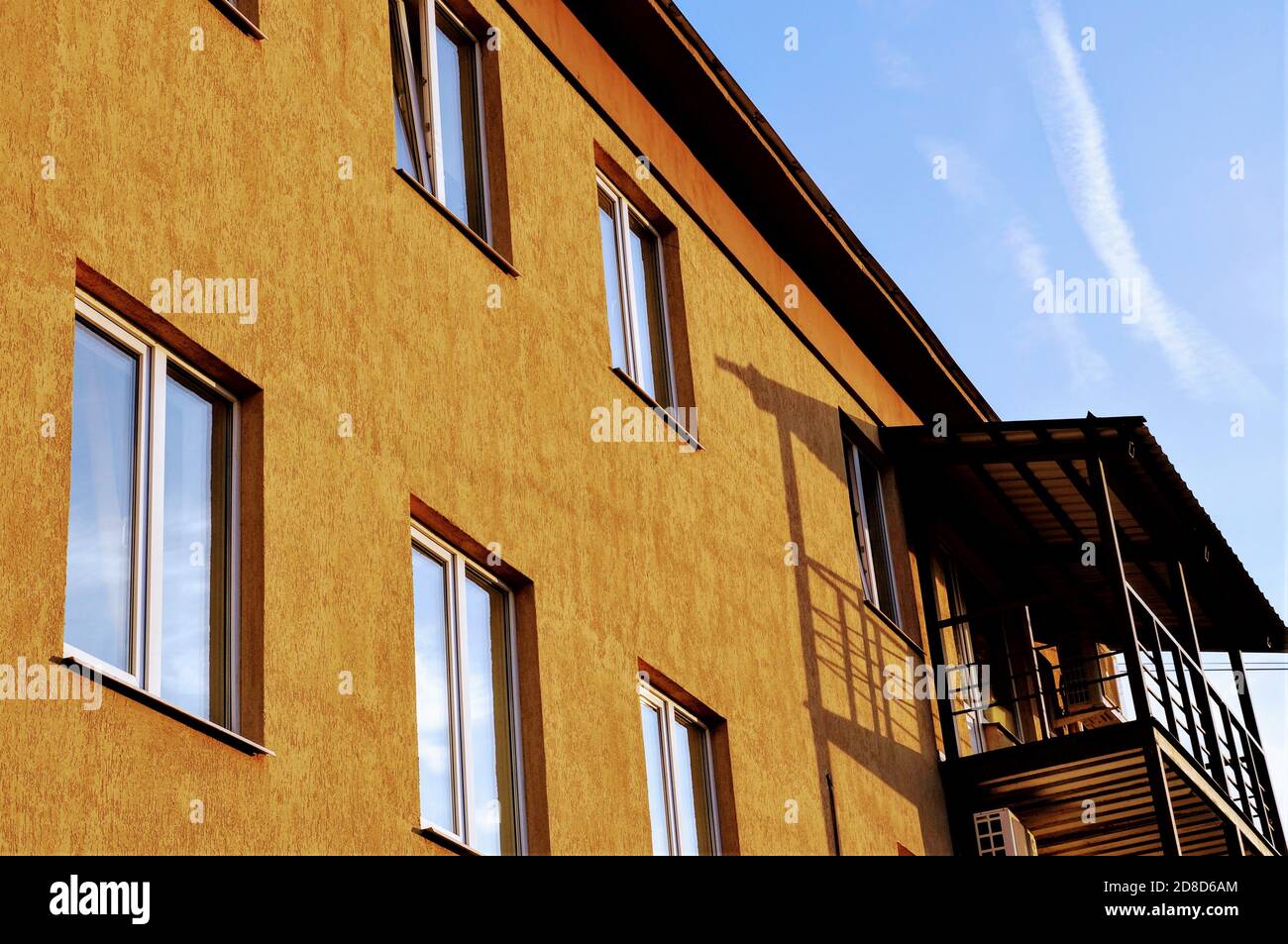 sunlit house facade with shadow from balcony Stock Photo - Alamy