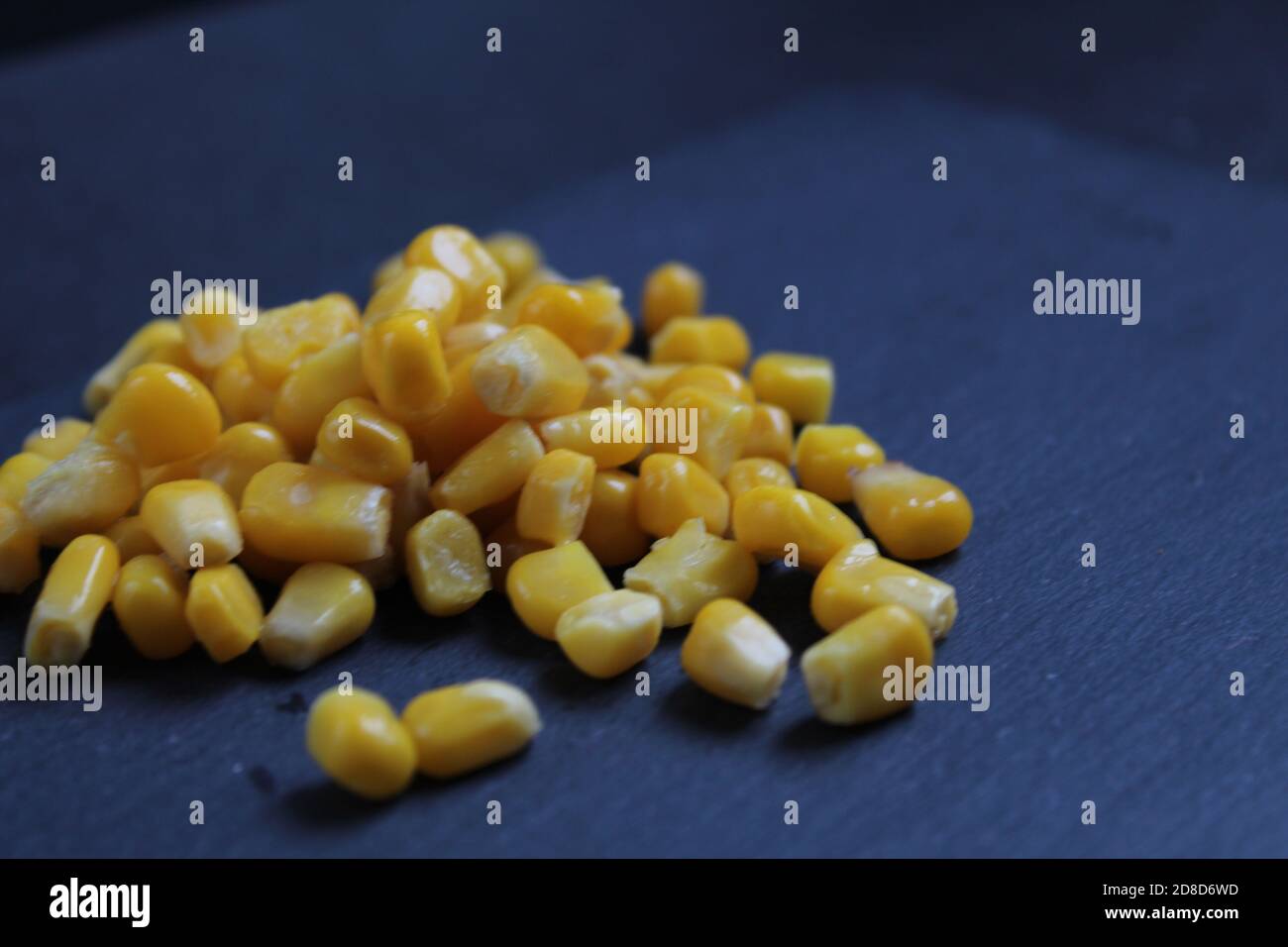 Breakfast lunch or dinner sweet sweet corn is piled up on a dark black ...