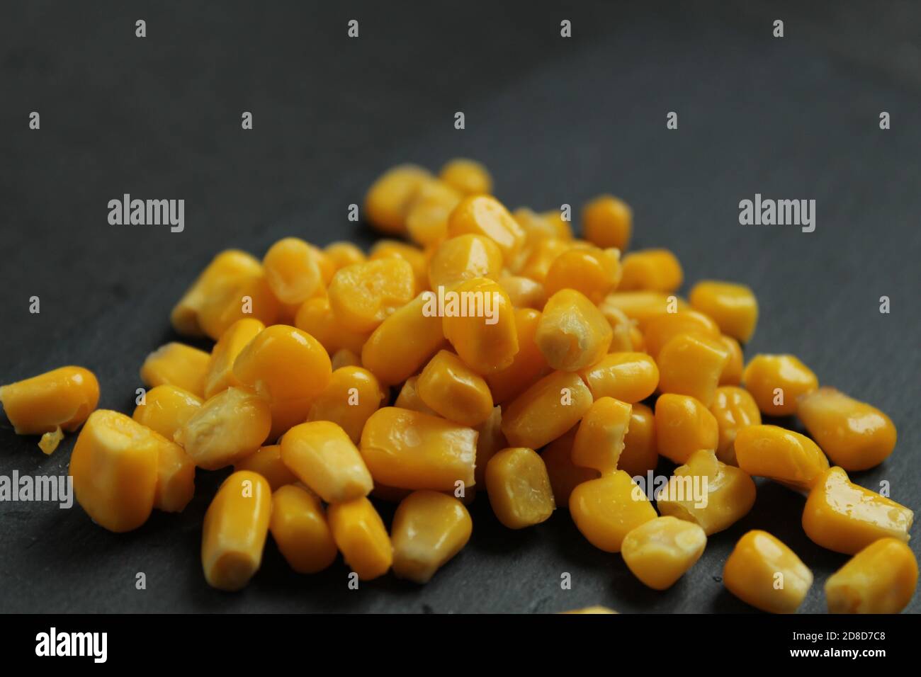 food background sweet sugar yellow corn lying in a pile on a rock dark ...