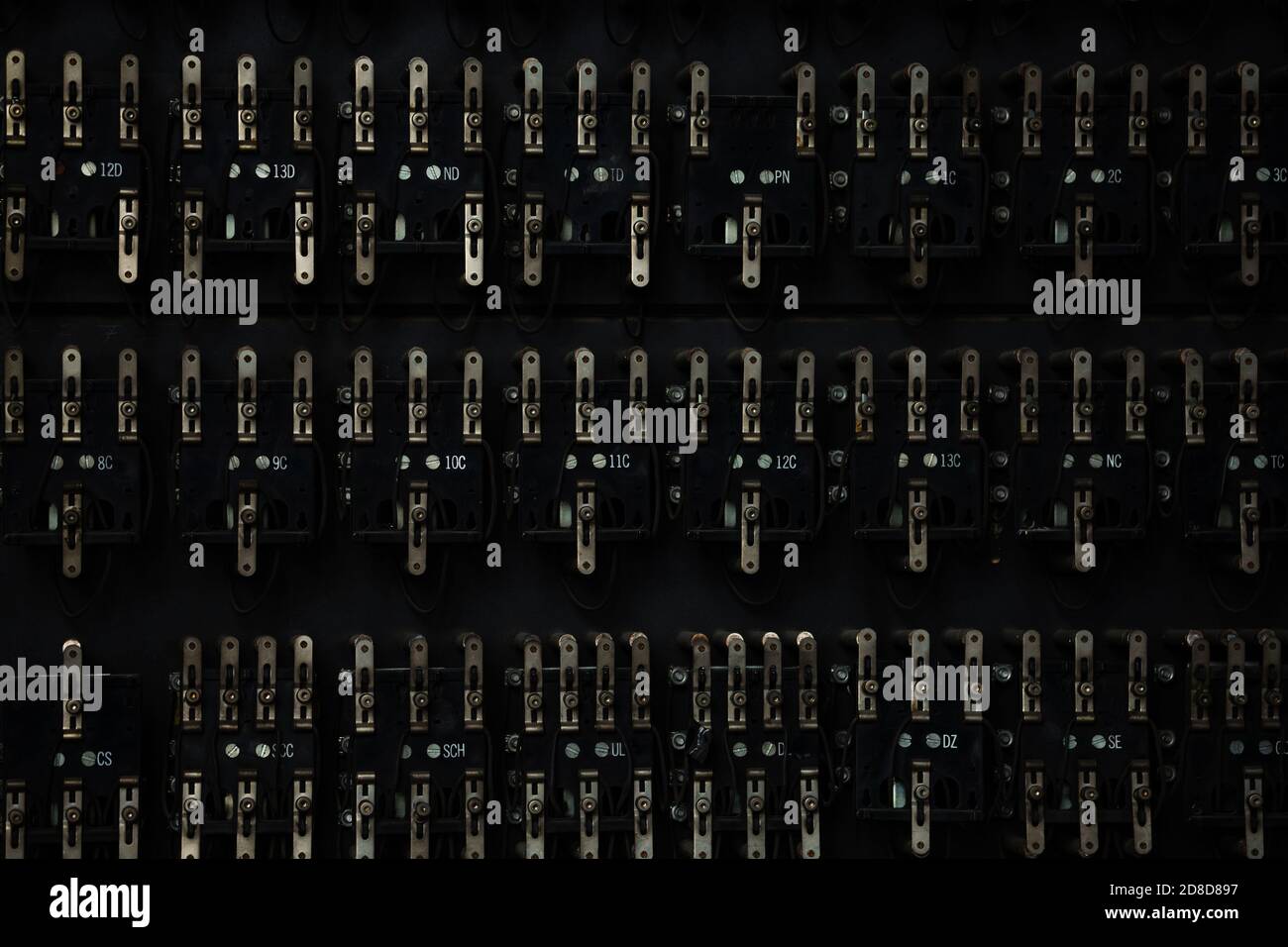Old telephone control panel with tumblers and switches over black back ...