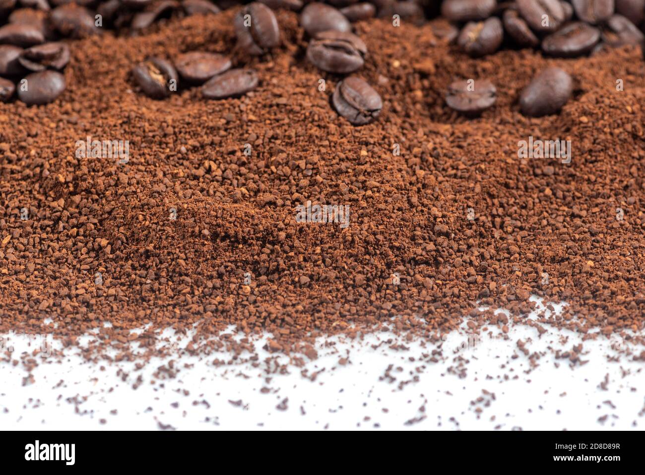 Closed up ground coffee powder and blurred roast beans background ...
