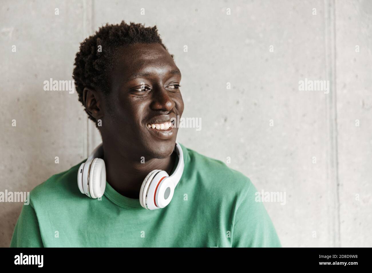 Image of joyful young african american man in headphones looking aside ...
