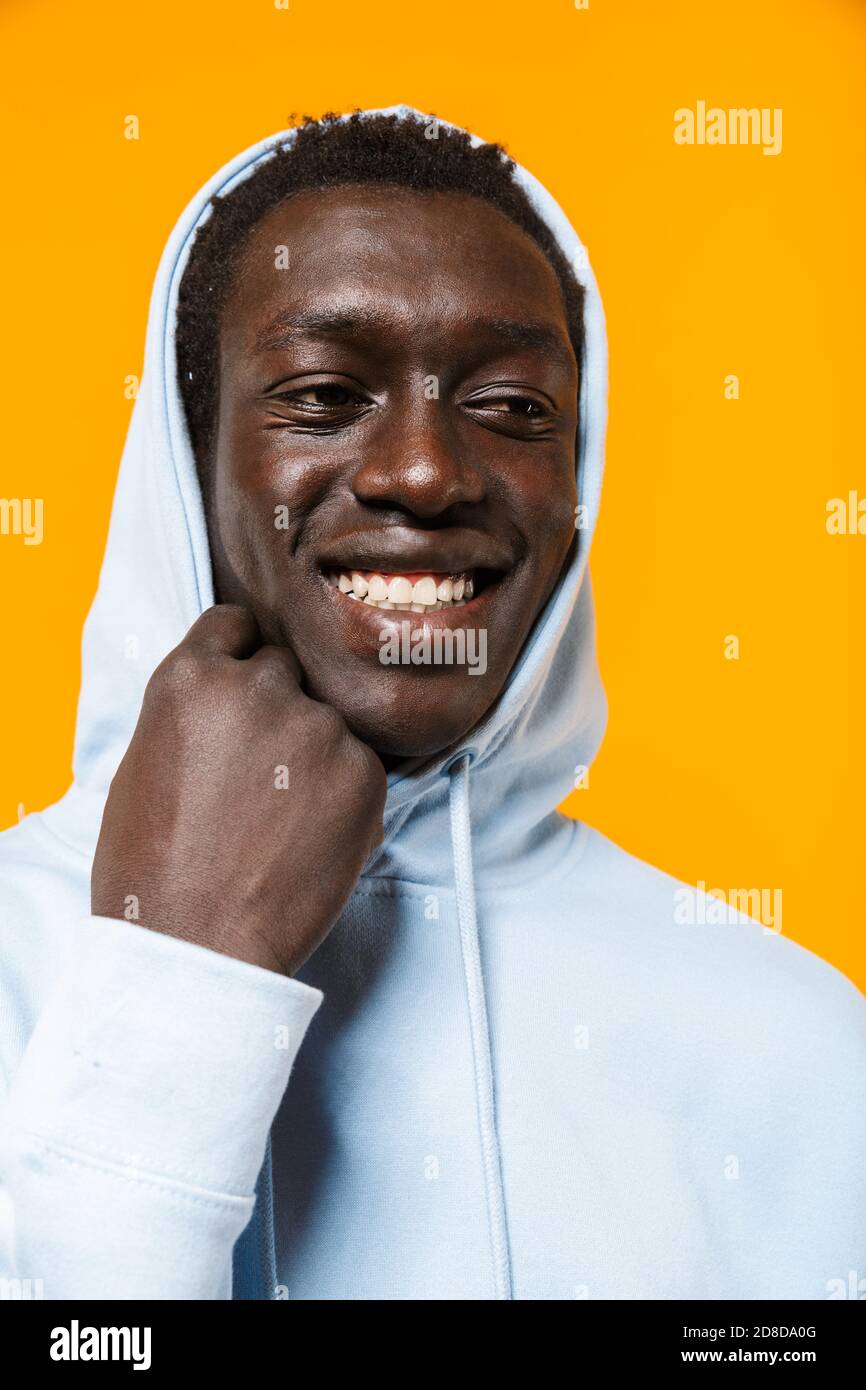 Image of pleased african american guy in streetwear hoodie standing and ...