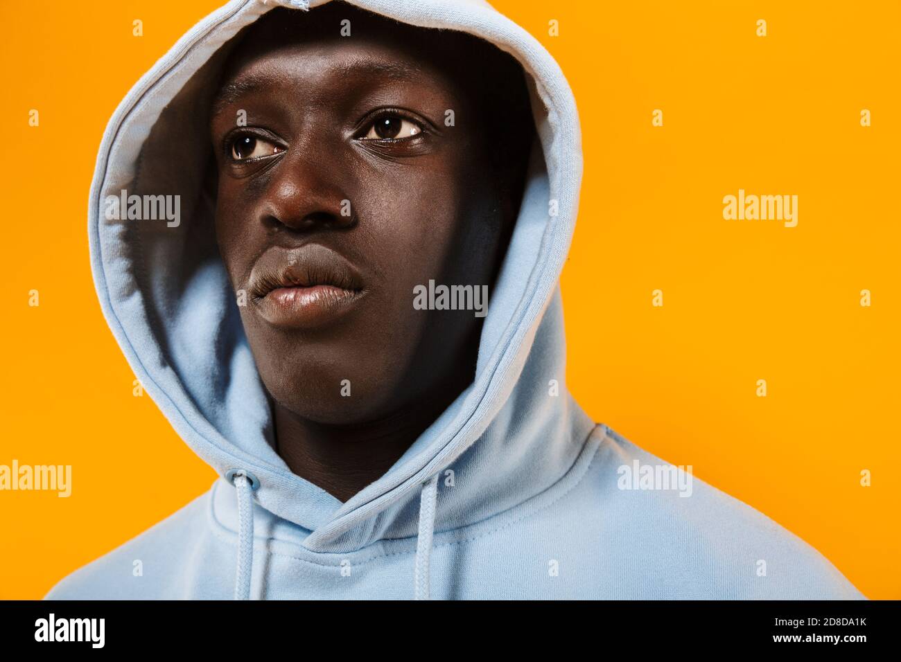Image of young african american guy wearing hood looking aside at ...