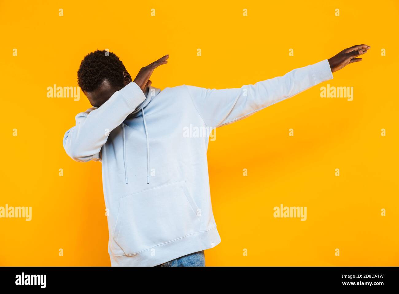 Image of young african american guy in streetwear hoodie making dab ...