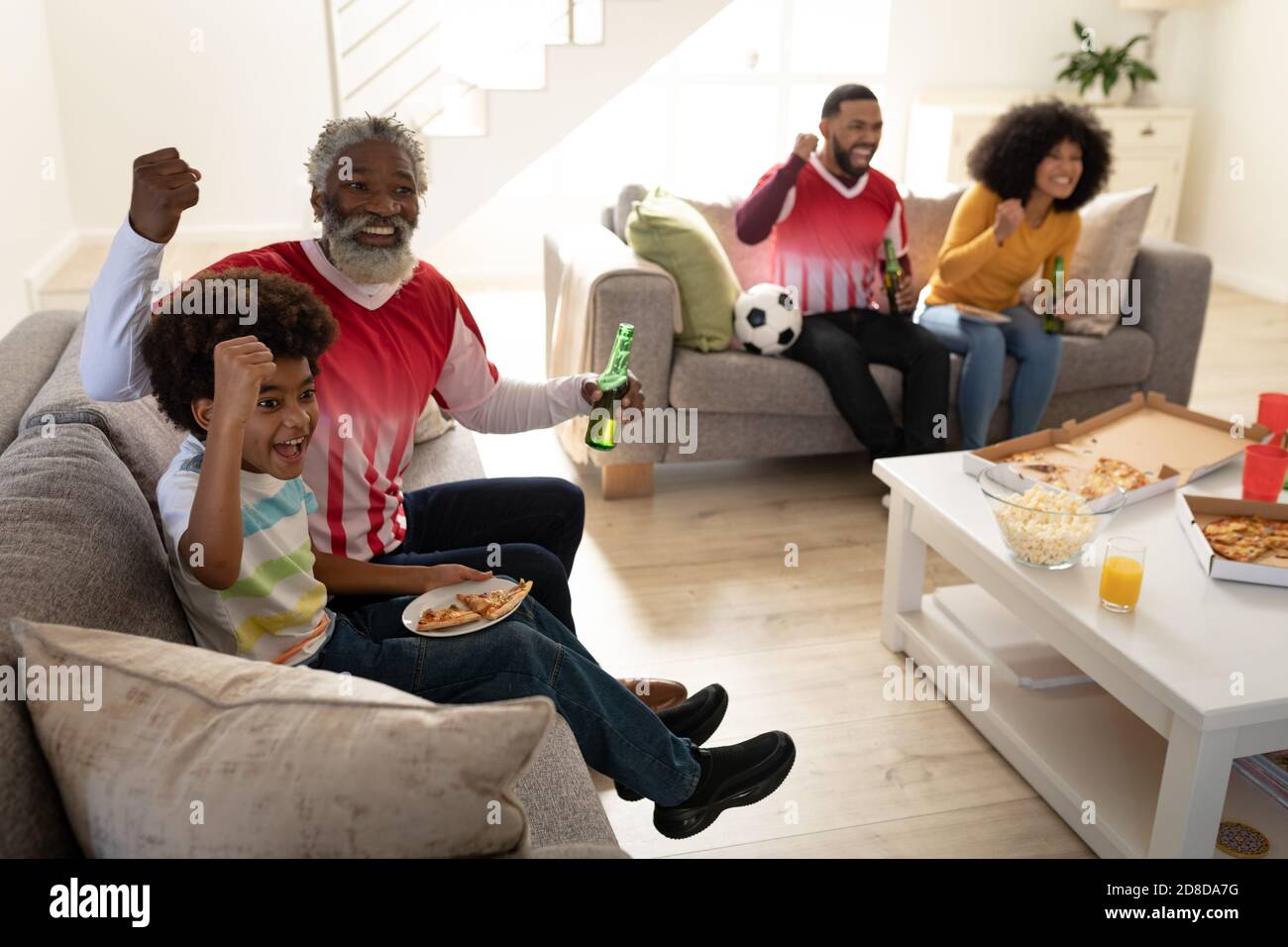Multi generation family cheering while watching sports on TV Stock ...