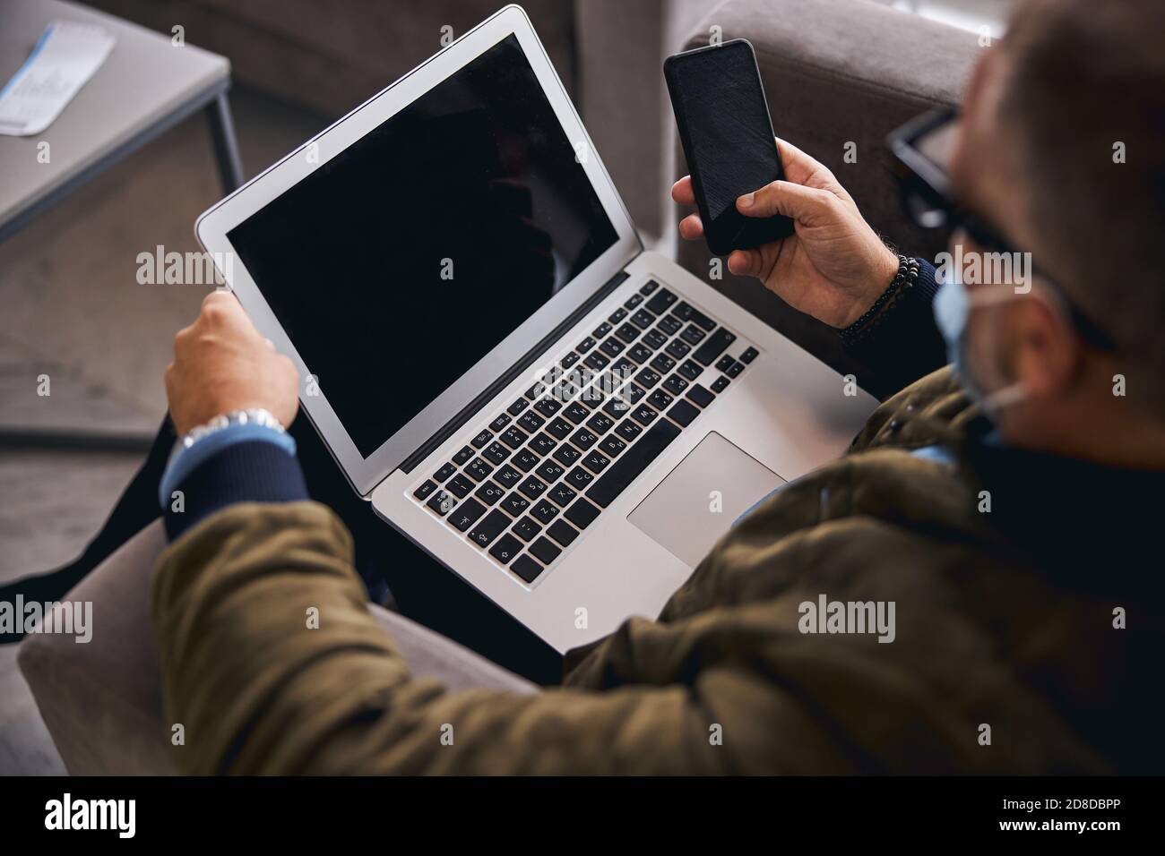 Man in a mask holding gadgets in his hands Stock Photo - Alamy