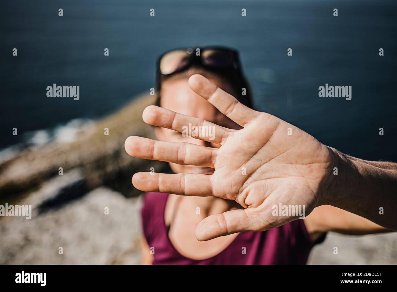 Playful woman trying to hide from photographer camera to avoid pics ...