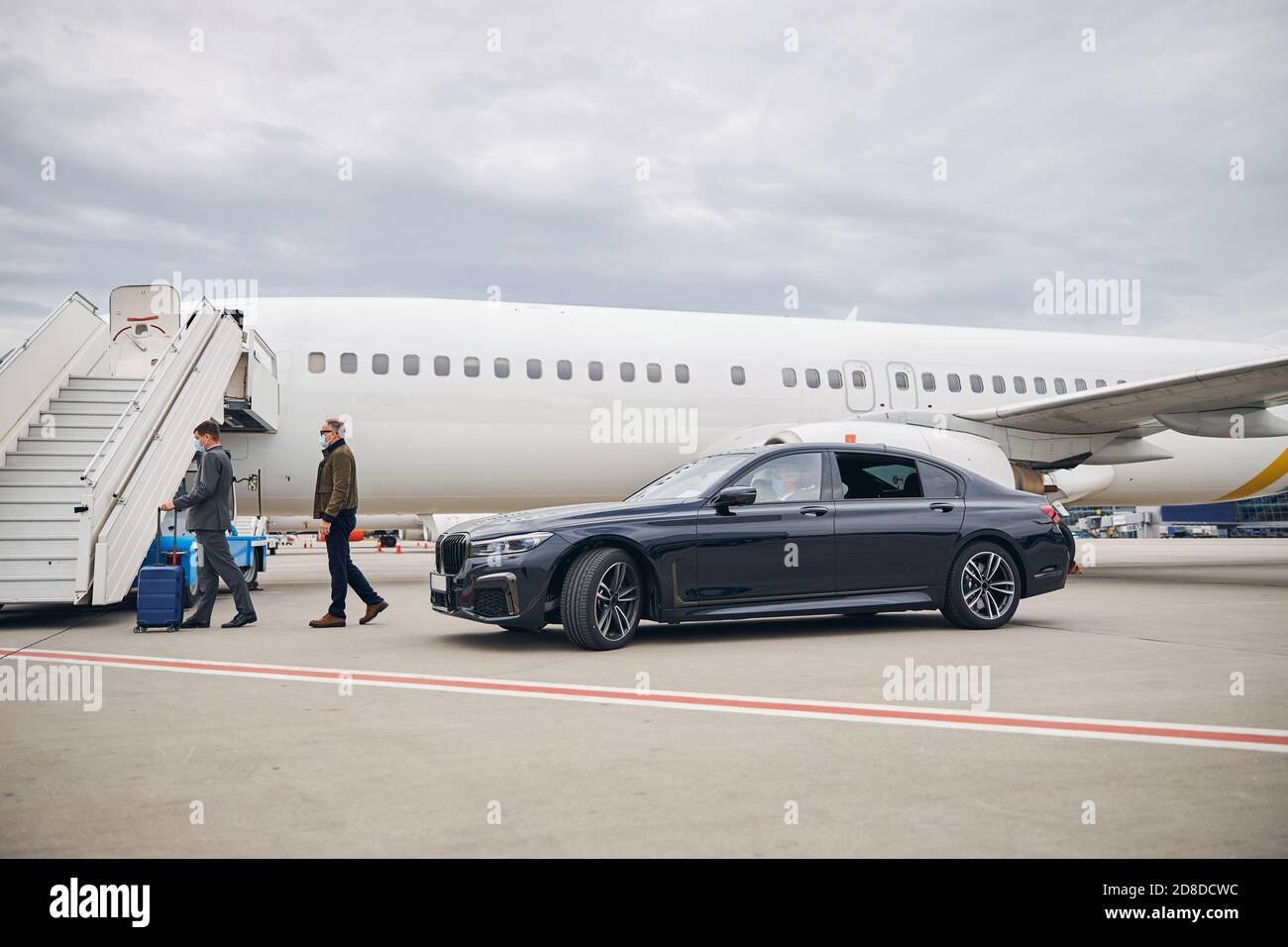 First class passenger and an airline employee approaching the airplane ...