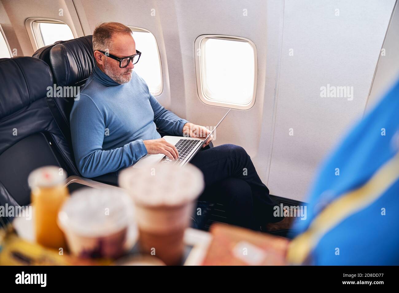 Air traveler using his computer on the plane Stock Photo - Alamy