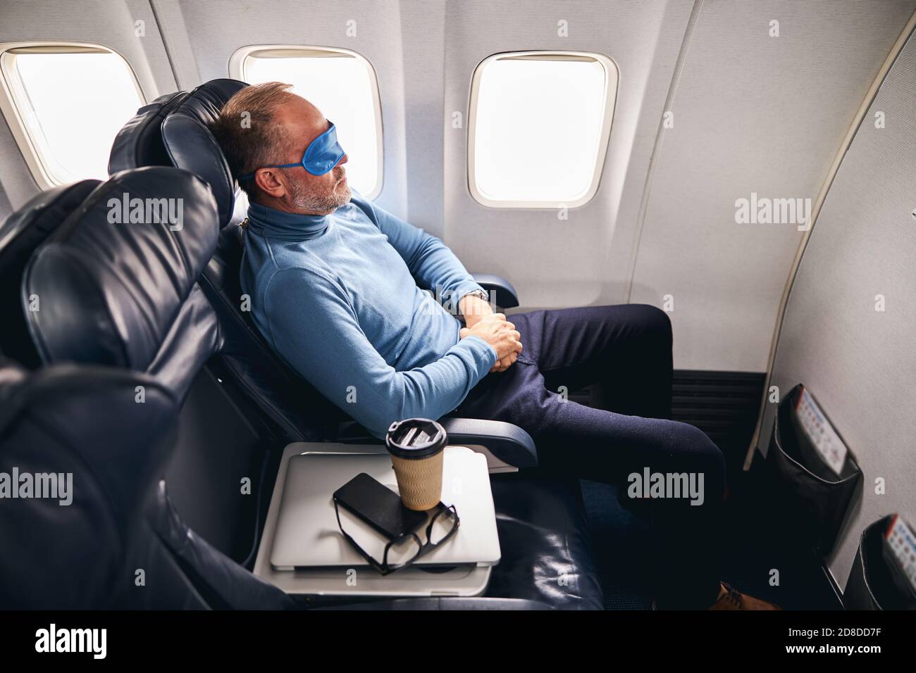 Man in the sleep mask relaxing on the plane Stock Photo - Alamy