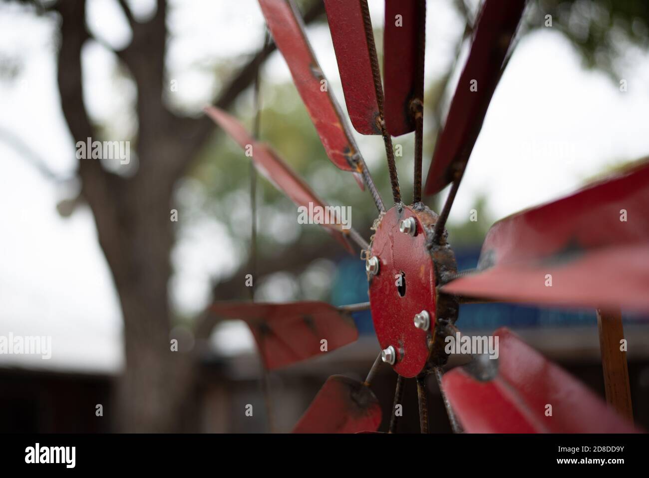 red metal windmill in front of a tree Stock Photo - Alamy